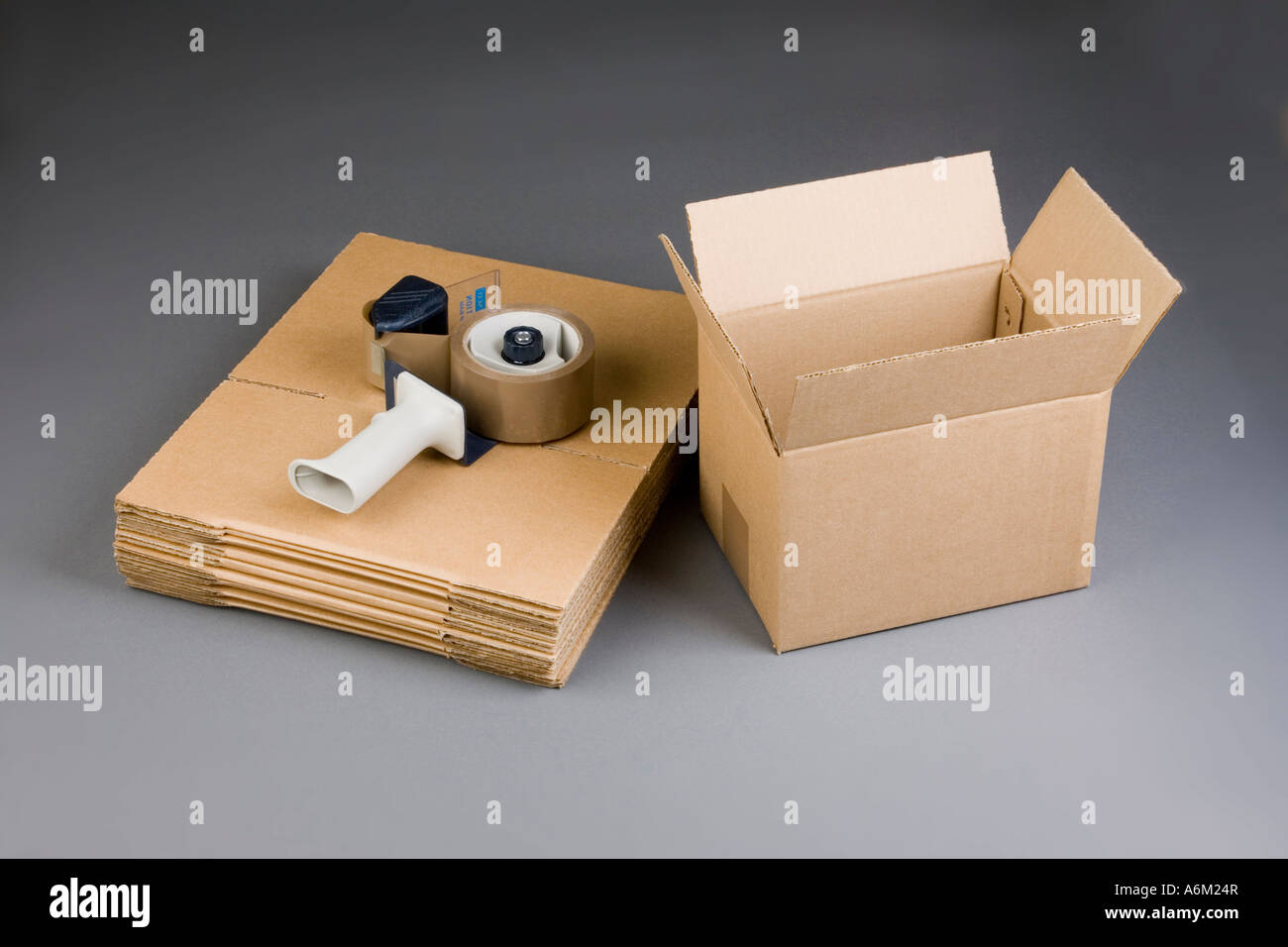 cardboard boxes in flat form and adhesive tape dispenser Stock Photo ...
