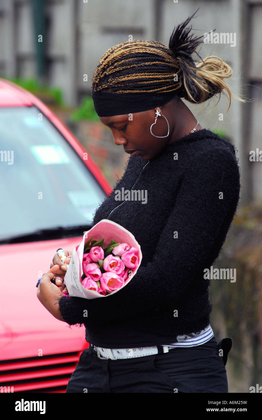 A young woman writing a floral tribute to the murdered 16 year old ...