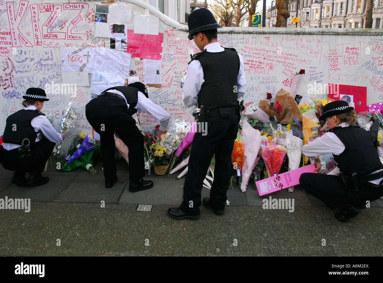 Police officers placing floral tributes to murdered teenager Kodjo ...
