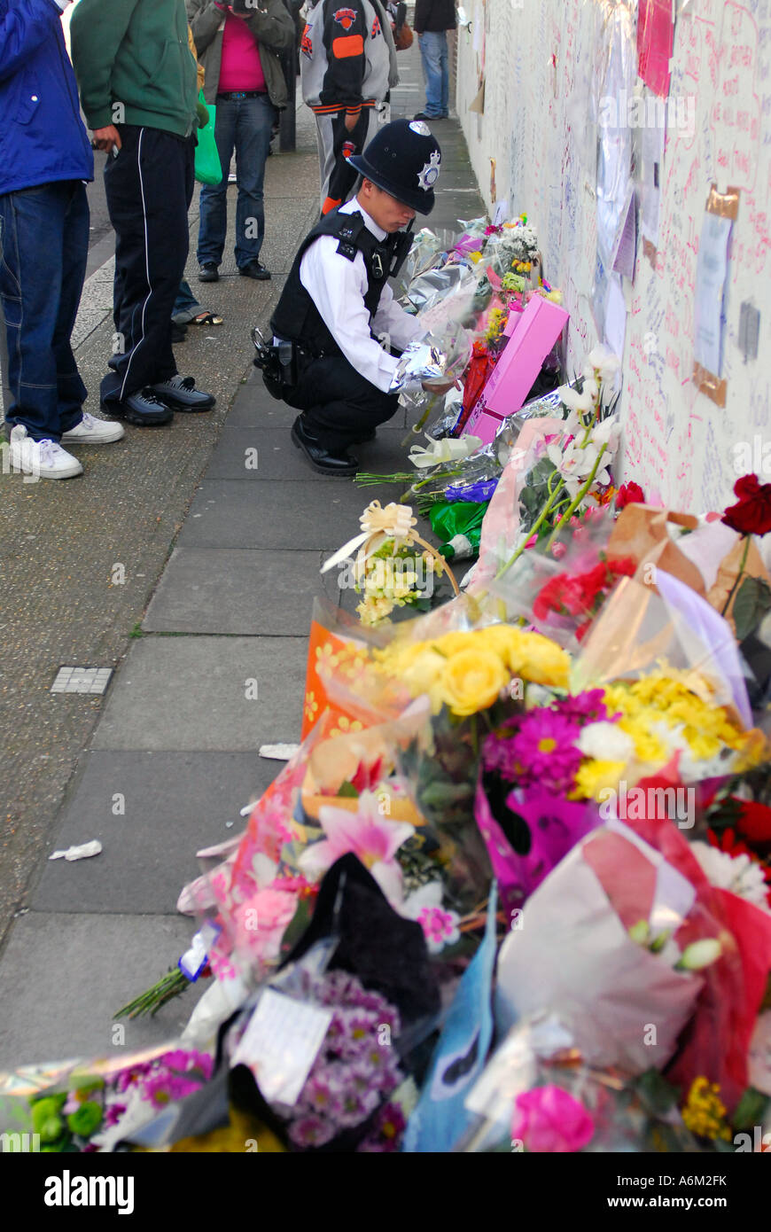 Police officer placing floral tributes to murdered teenager Kodjo Yenga ...