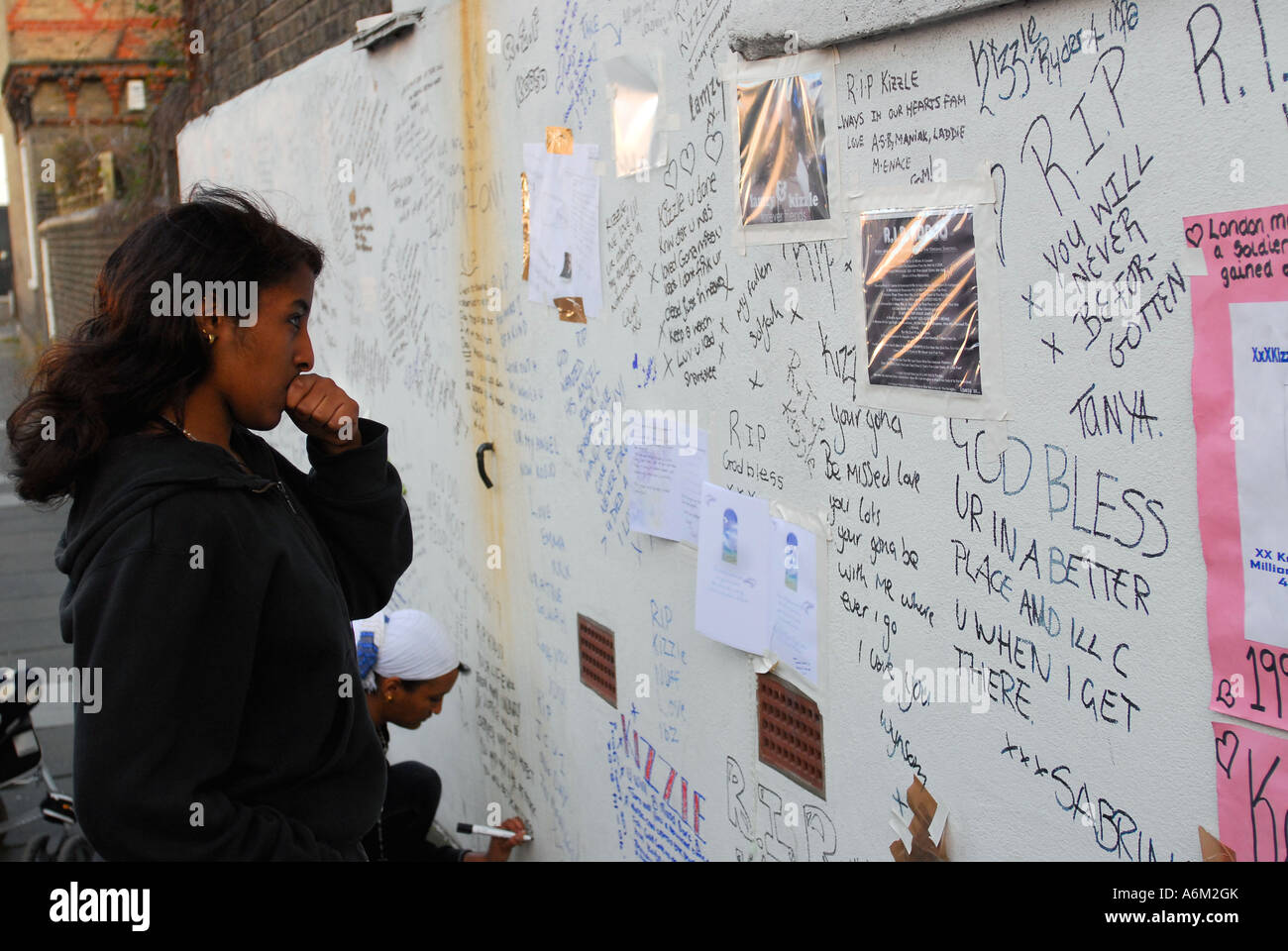 A female mourner peruses written tributes to murdered teenager Kodjo ...