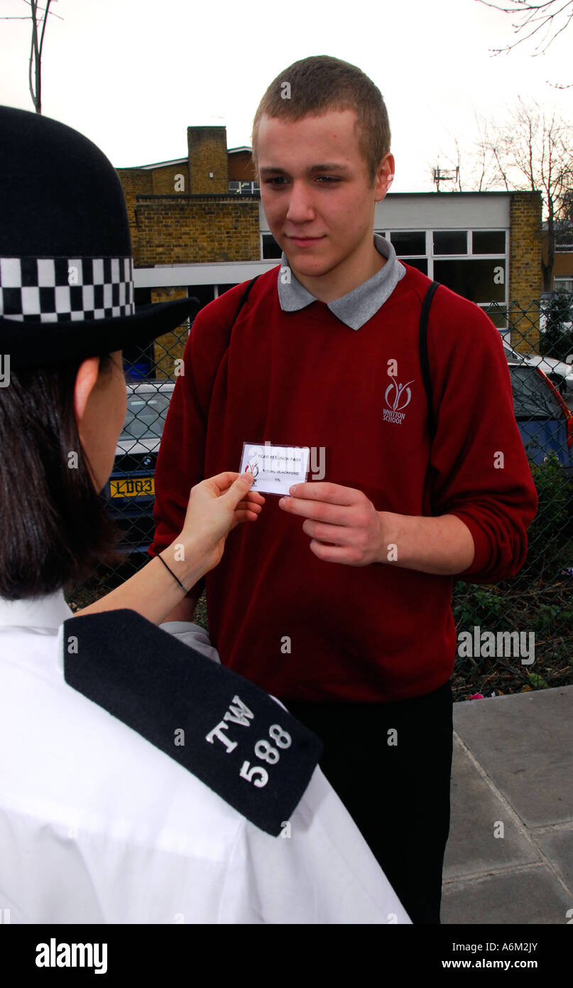 Female PC checking pupil's identity badge outside Whitton School ...