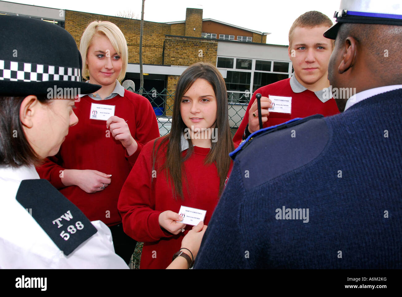 Police Officer and PCSO checking pupils' name badges as part of ...