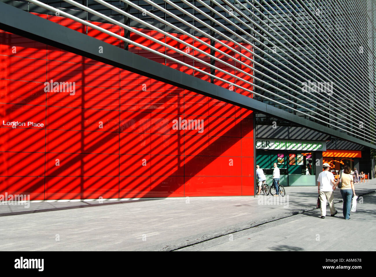 Red cladding panels on exterior of offices with shadow lines from slats ...