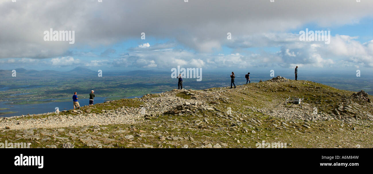 A scenic panorama with six hikers at the top of Croagh Patrick Stock ...