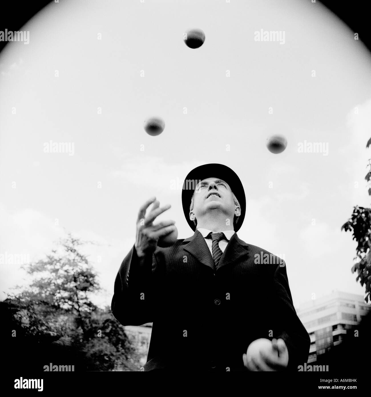 Man in bowler hat juggling Stock Photo - Alamy