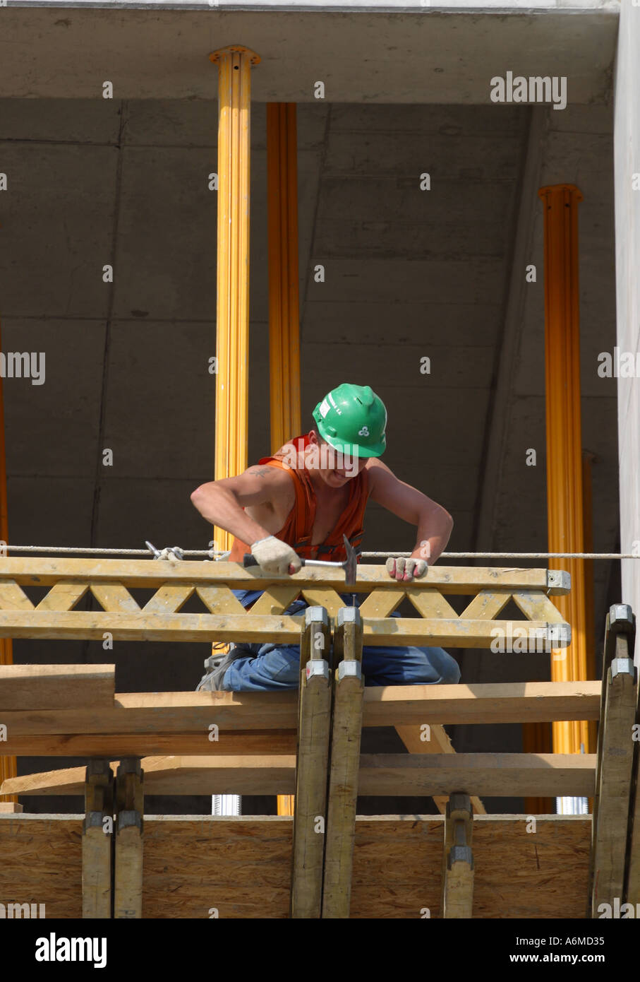Construction worker at work hammering nails on a new build office ...
