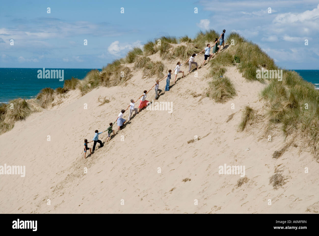 Chain of people on sand dune Stock Photo - Alamy