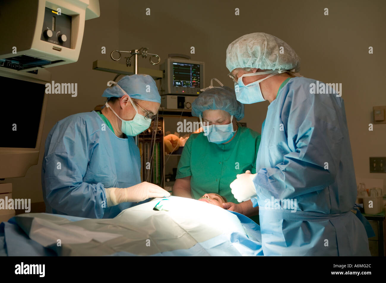 Doctors and nurses gather around operating table during surgery Stock ...