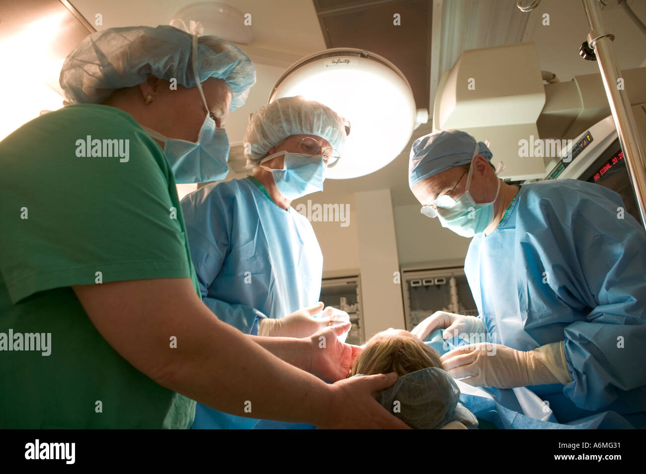 Doctors and nurses gather around operating table during surgery Stock ...