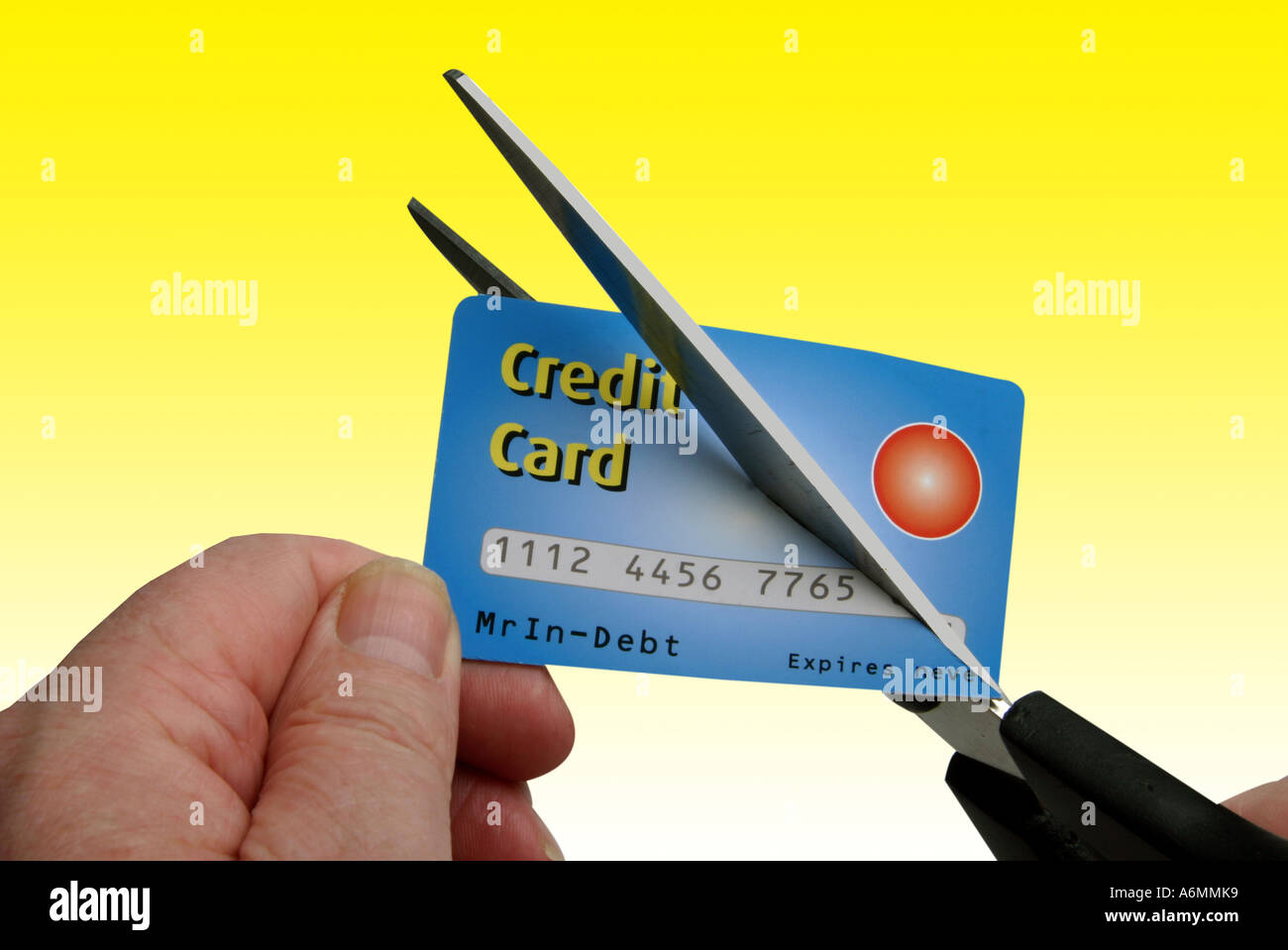 Credit card being cut in half by scissors Stock Photo - Alamy