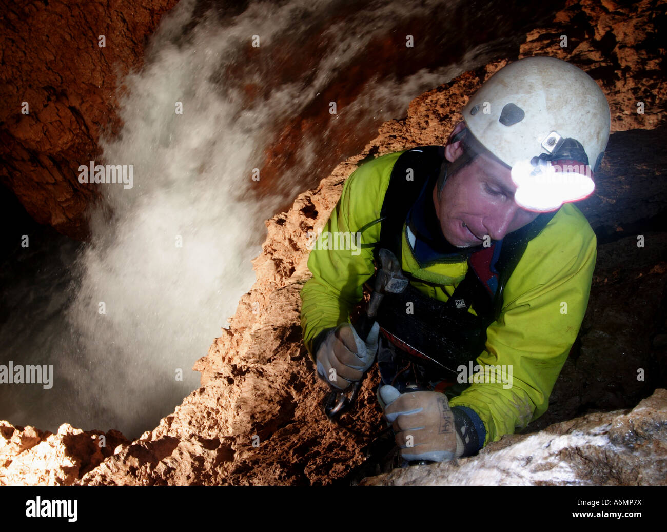 A British cave explorer hammers in another bolt to make this huge ...