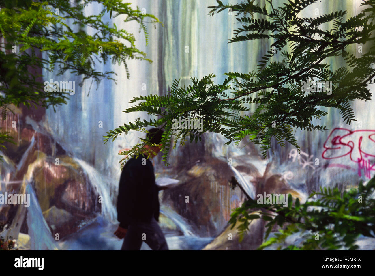 Berlin, Germany; man walking past waterfall mural Stock Photo - Alamy