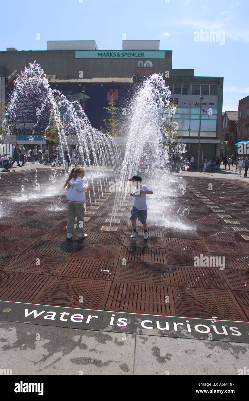two children playing in public fountain williamson square liverpool UK ...