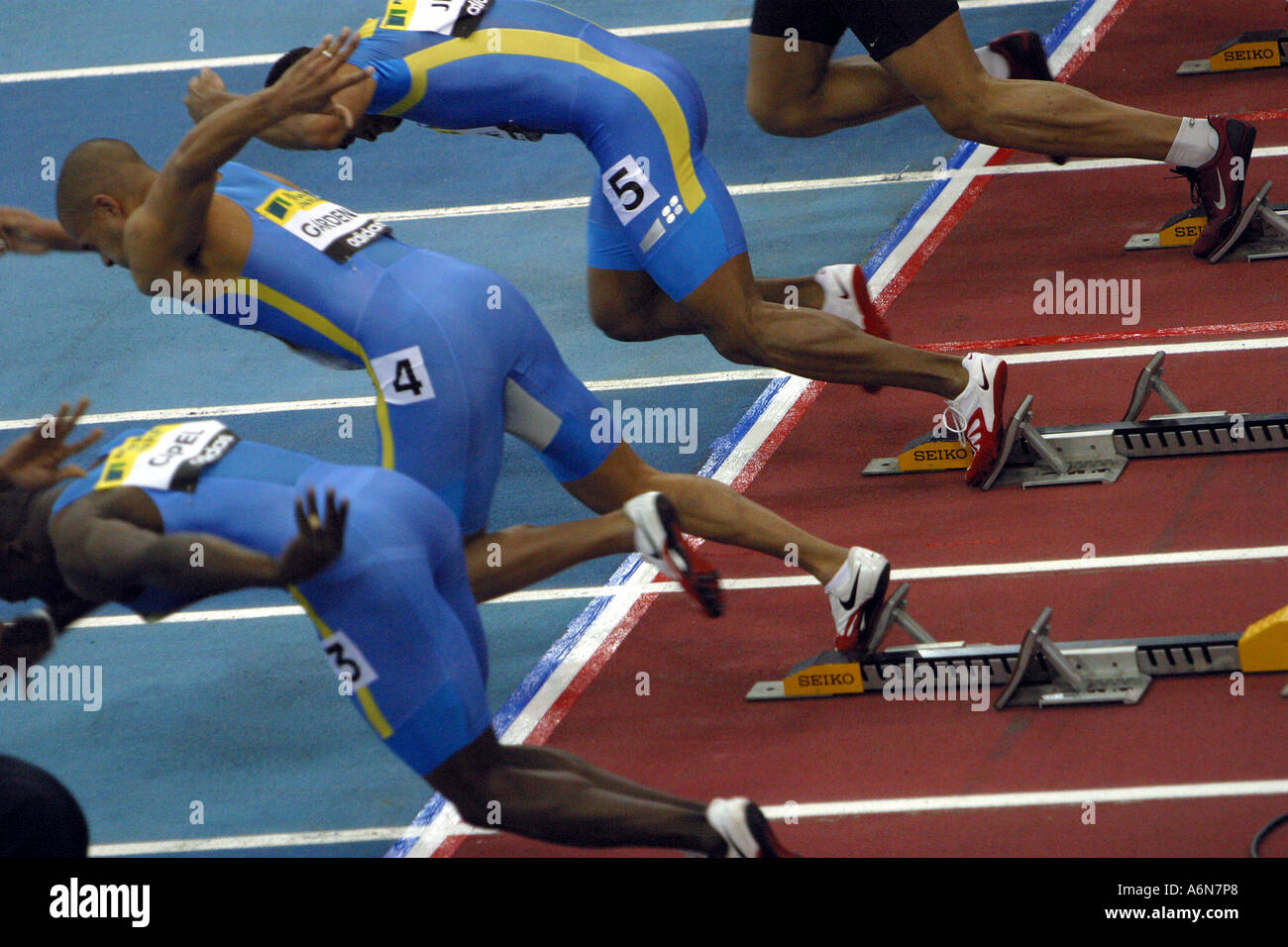 mens 60 meter sprinters explode from the starting blocks in an indoor ...