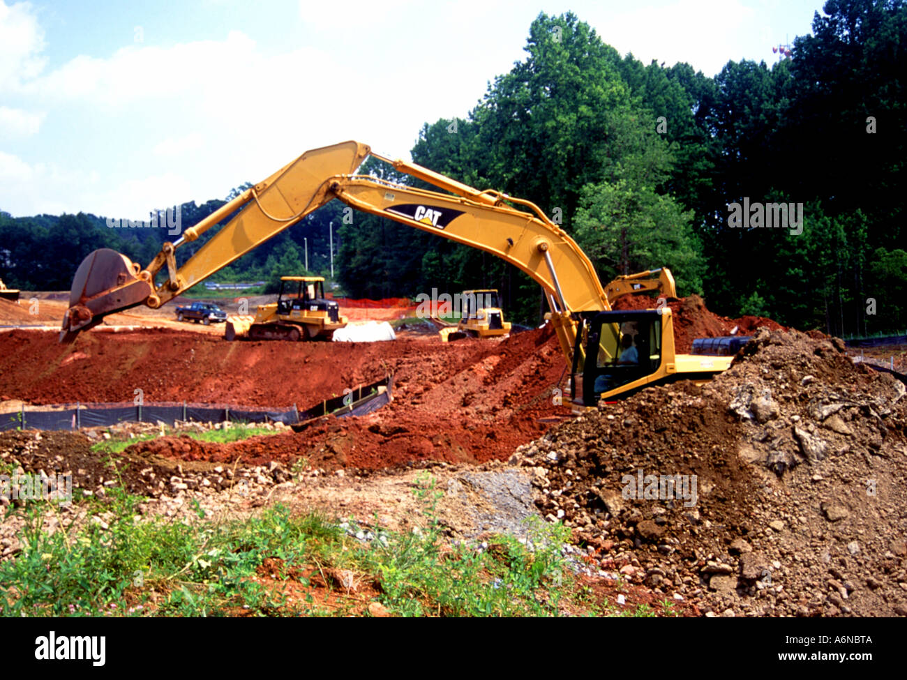 Heavy construction equipment moves earth as land is cleared for new ...
