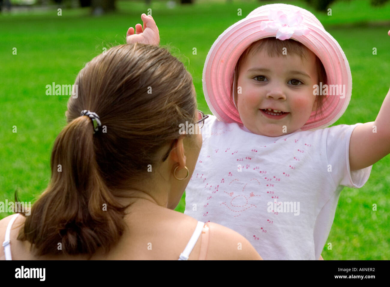Smiling child looking over mothers shoulder Stock Photo - Alamy
