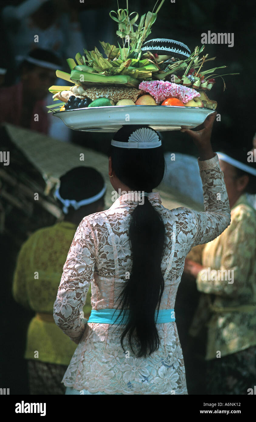 Balinese woman arrives at the temple with a religious offering Full ...
