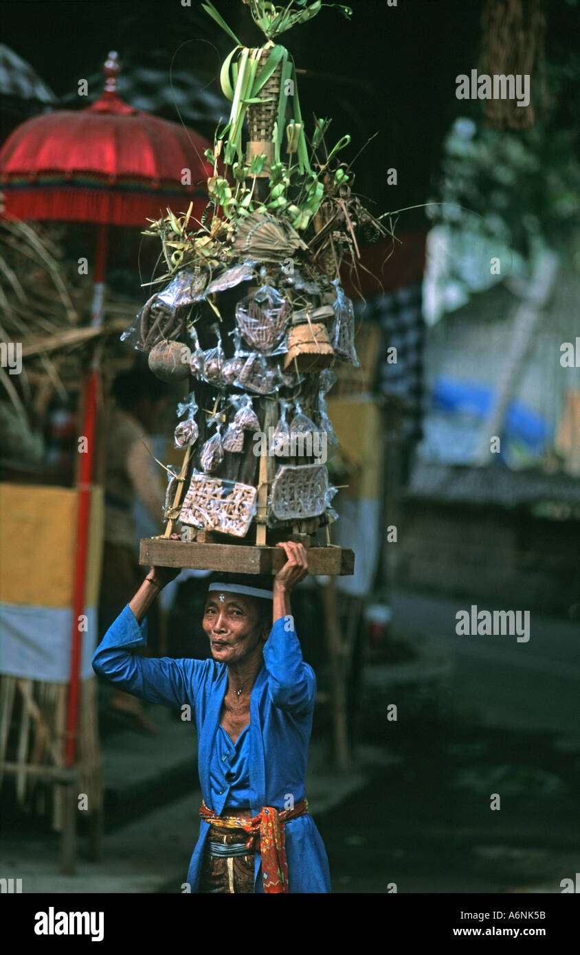 Balinese woman arrives at the temple overladen with a gigantic ...