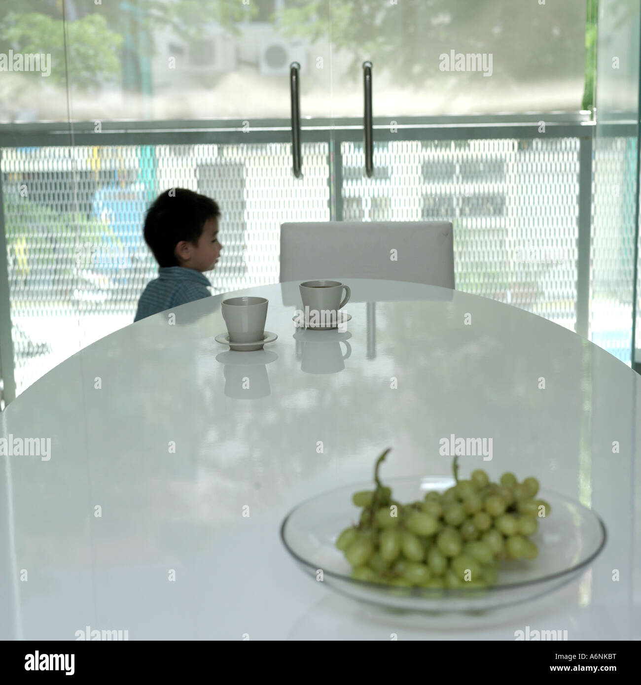 A young boy running around dining table Stock Photo - Alamy