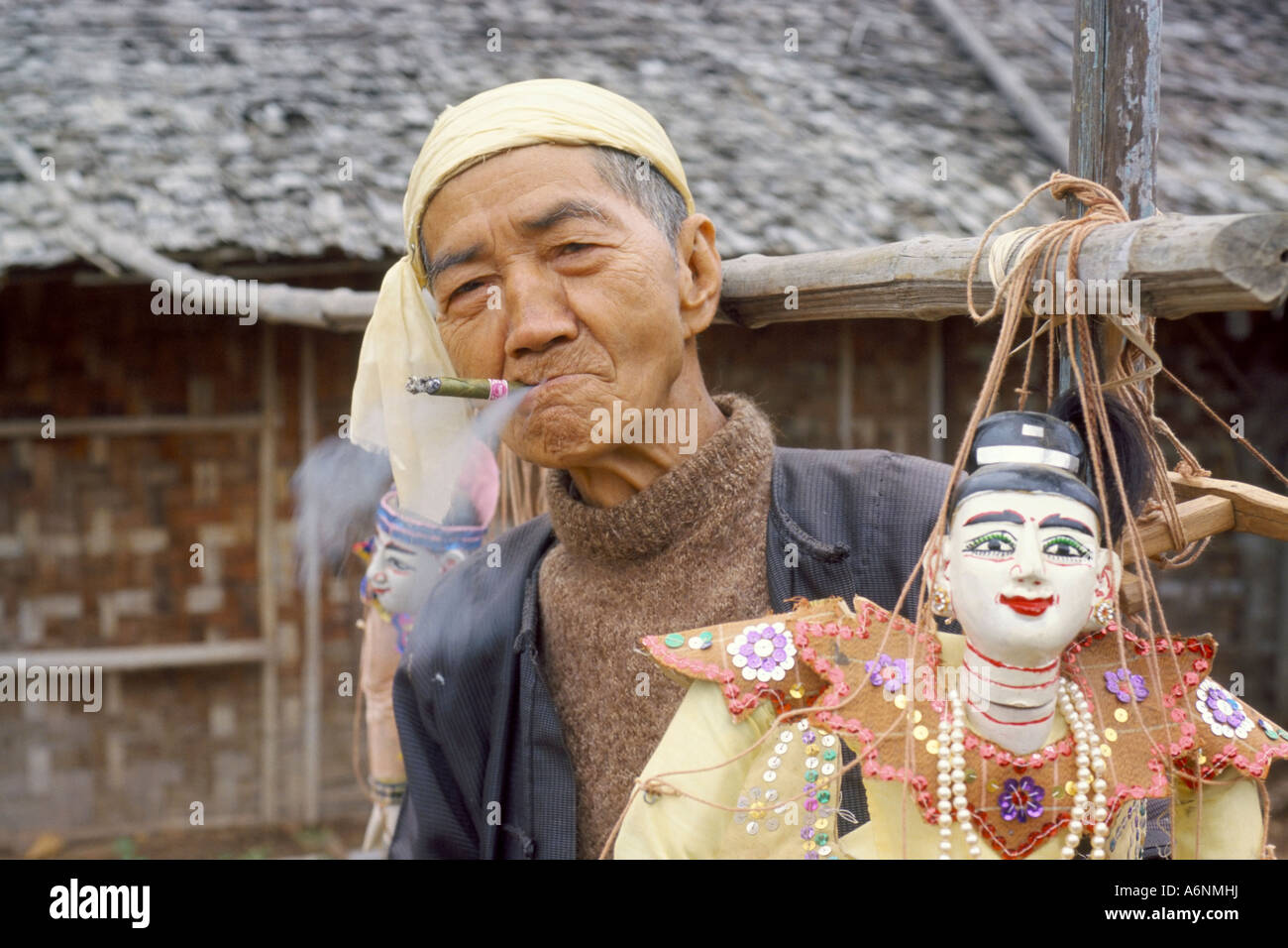 Puppeteer smoking cheroot with his puppets Yangon Rangoon Myanmar Burma ...