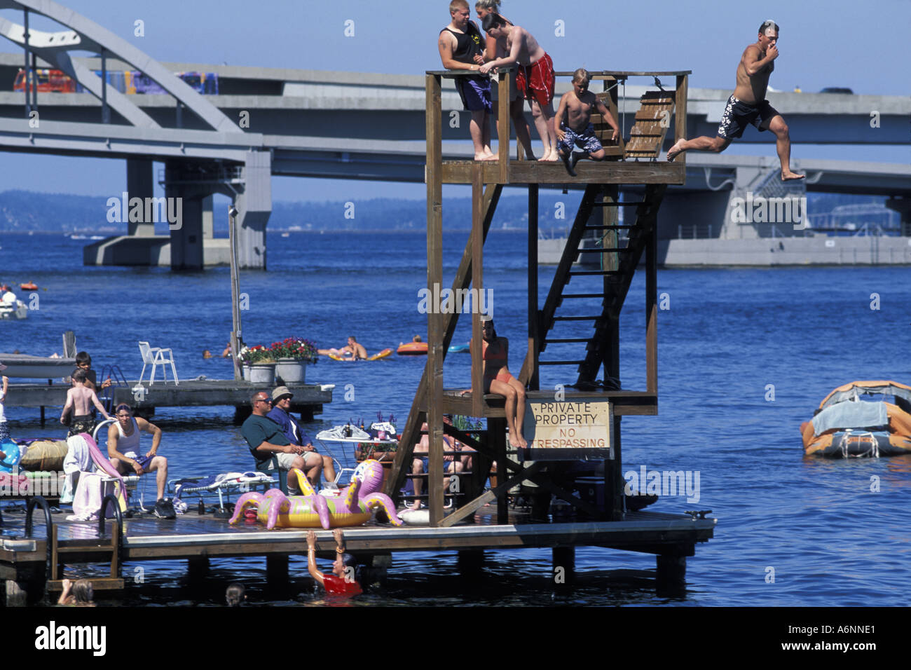 USA Washington Seattle Swimmers dive from platform on wooden dock on ...