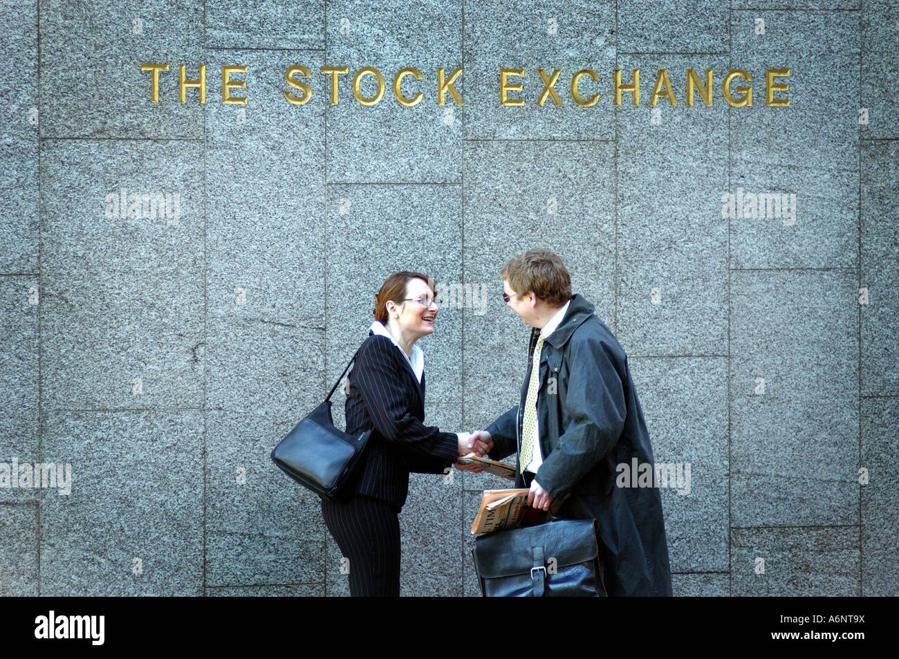 British business man woman shaking hands handshake stock exchange ...