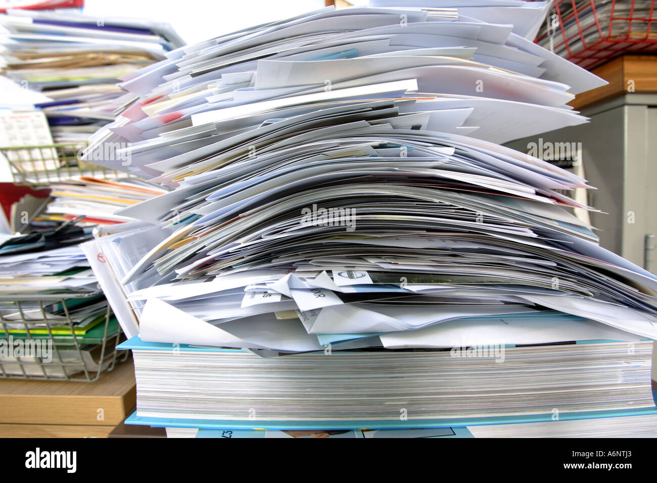 badly stacked paperwork on office desk Stock Photo - Alamy