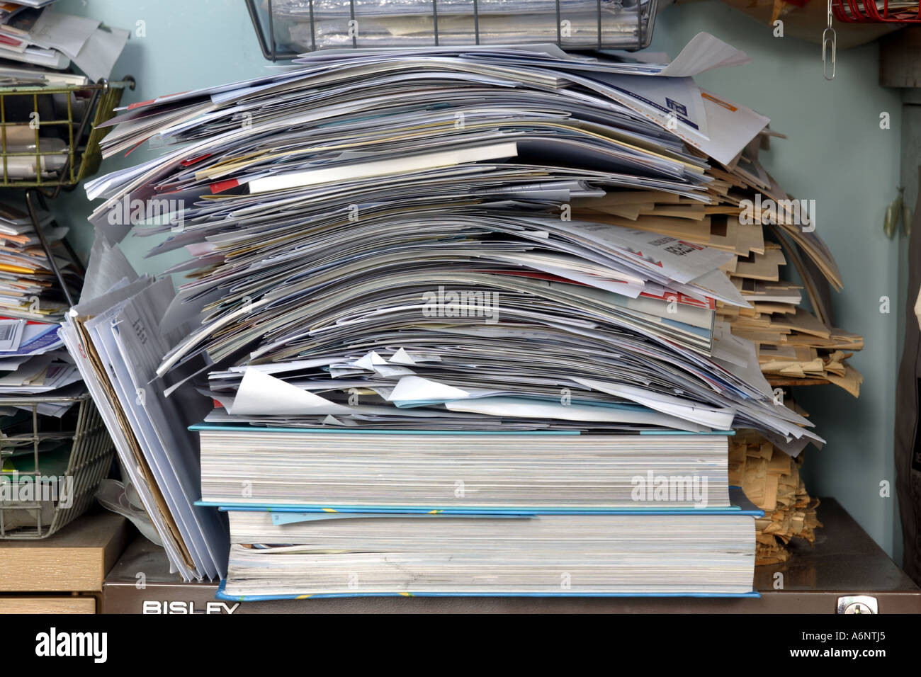 badly stacked paperwork on office desk Stock Photo - Alamy