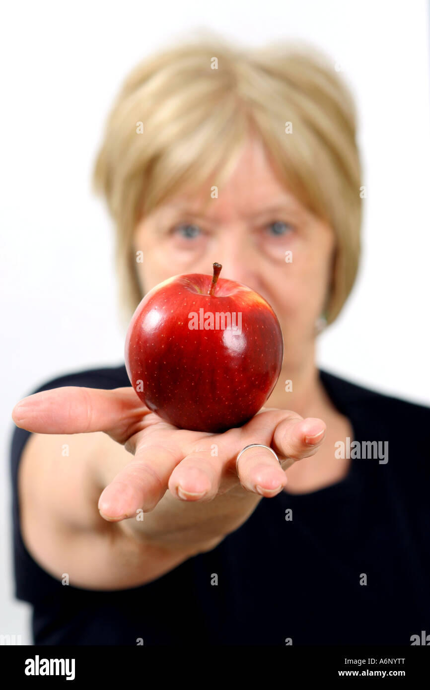 Older woman holding red apple in hand Stock Photo - Alamy