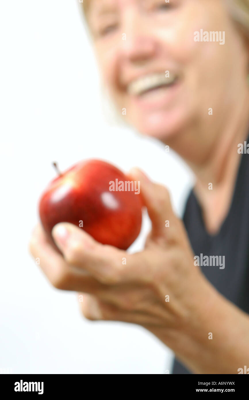 Older woman holding red apple in hand Stock Photo - Alamy