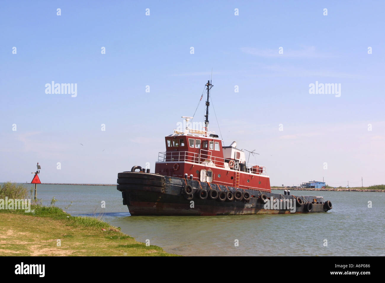Tug Boat Big red tug boat parked in the inlet waiting to go out to sea ...