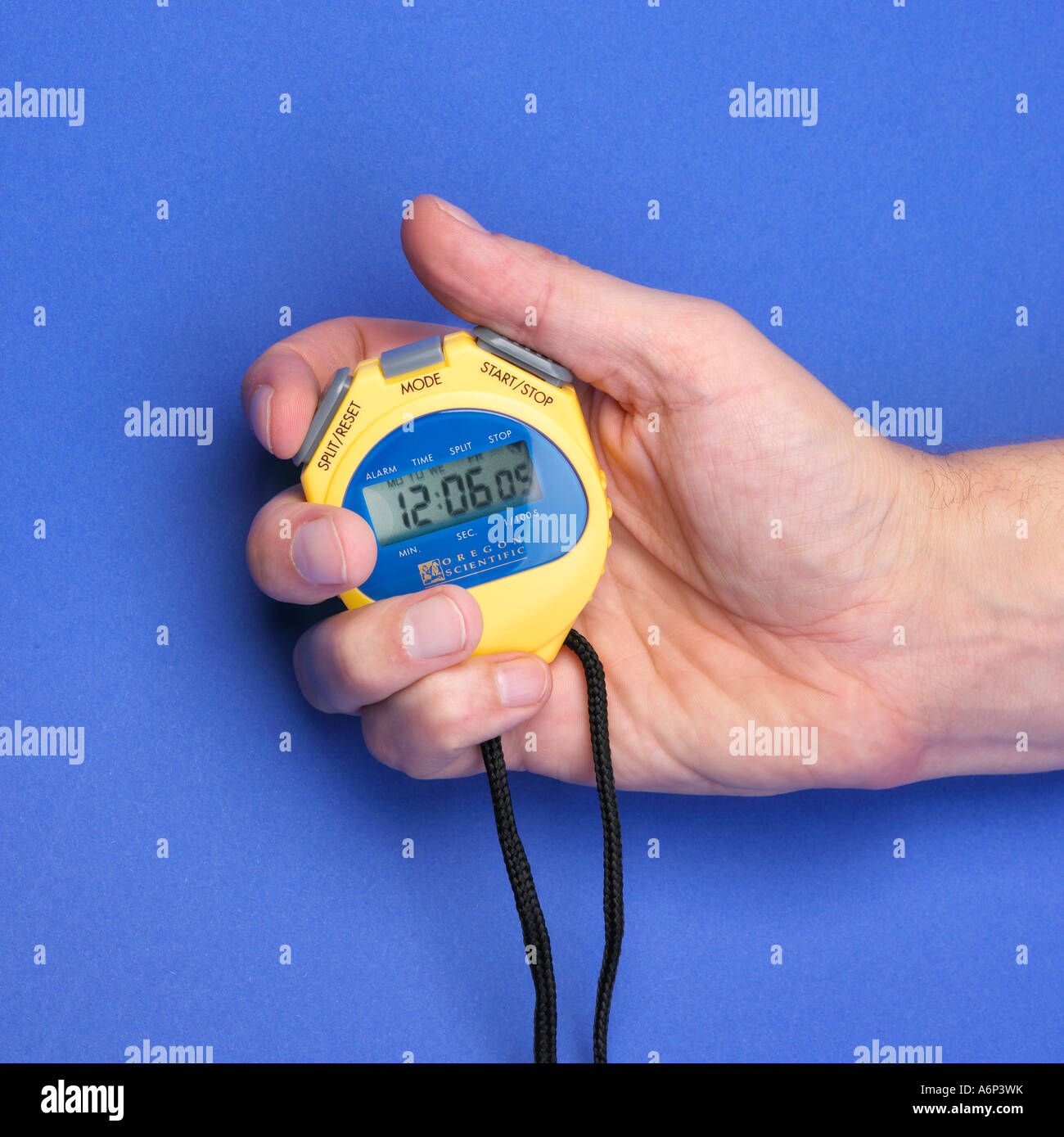 hand on a stop watch, on a blue background Stock Photo - Alamy