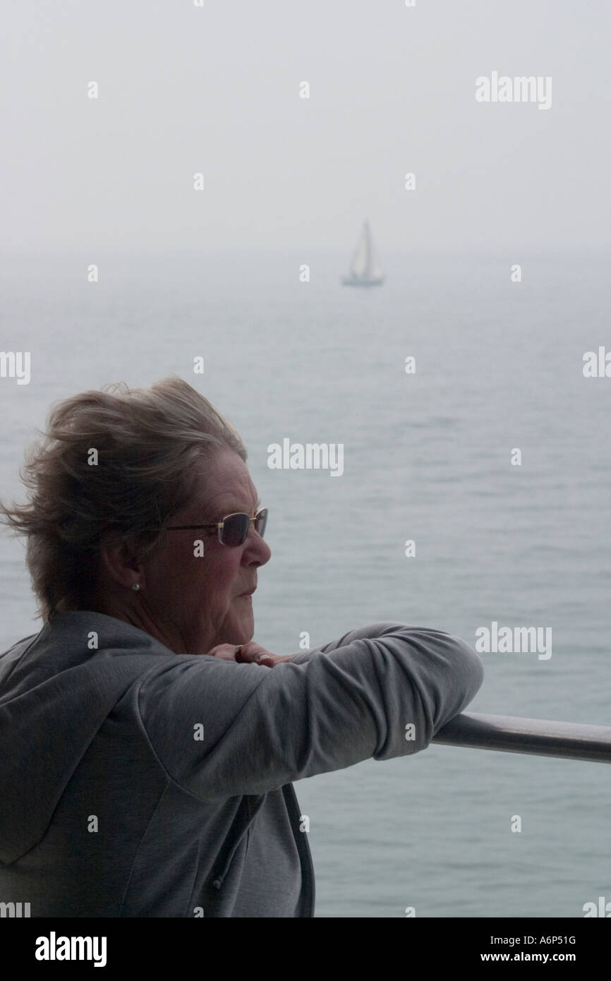 Mature woman with breeze in hair looking towards England as ferry ...