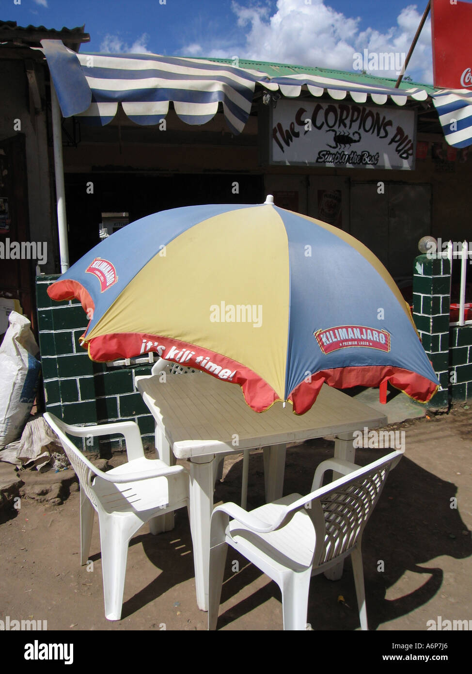 African pub exterior with umbrella and deck chairs Stock Photo - Alamy