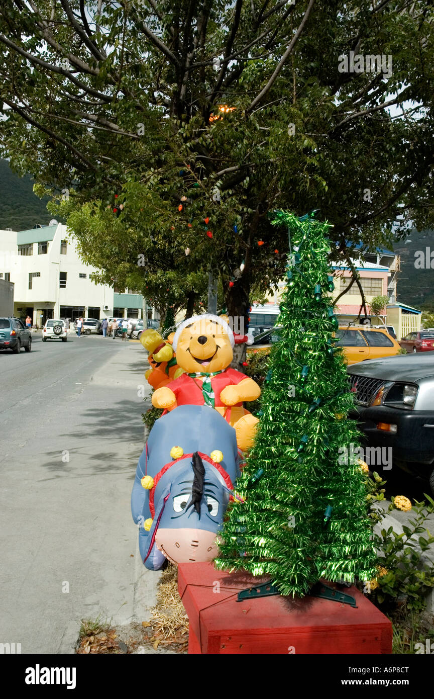 Christmas decorations set up at the side of the road in front of a busy ...