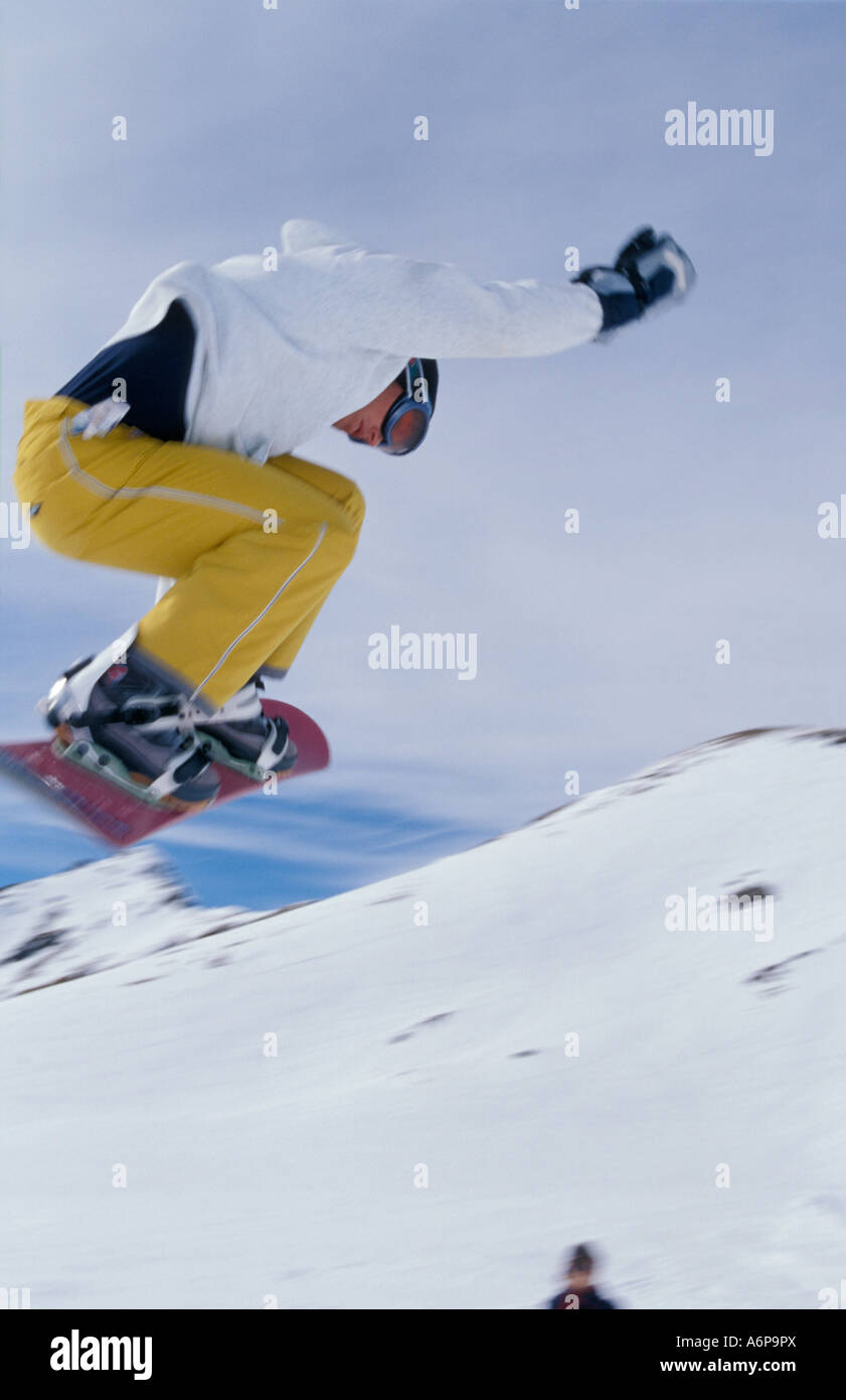 male snowboarder airborne grabbing his snowboard above Grindelwald ...