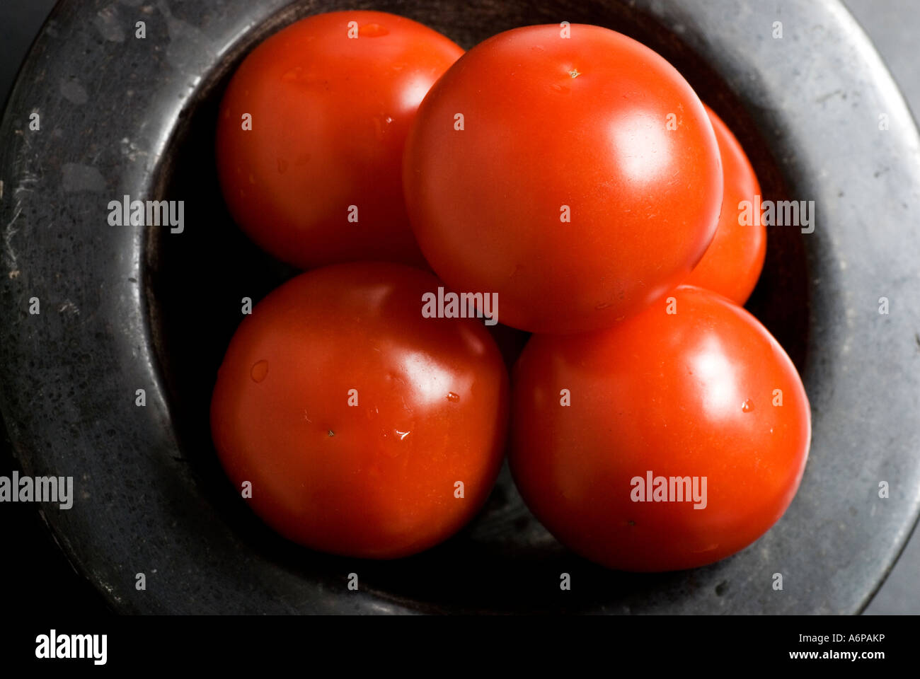 Tomatoes in a black marble bowl Stock Photo - Alamy