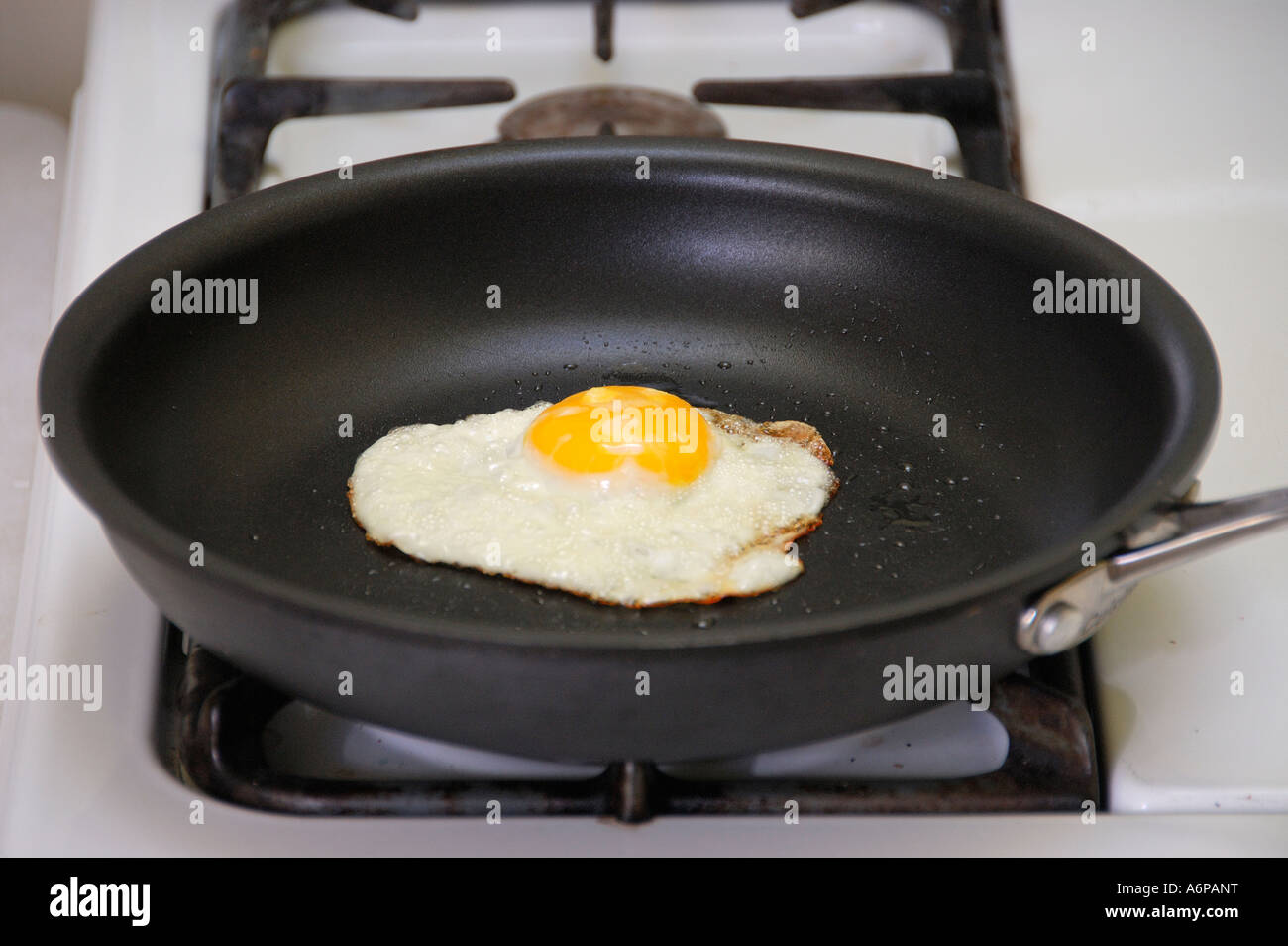 "One egg frying in "frying pan" on a stove Stock Photo - Alamy