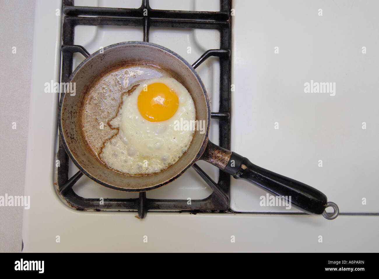 "One egg frying in small "frying pan" on a stove Stock Photo - Alamy