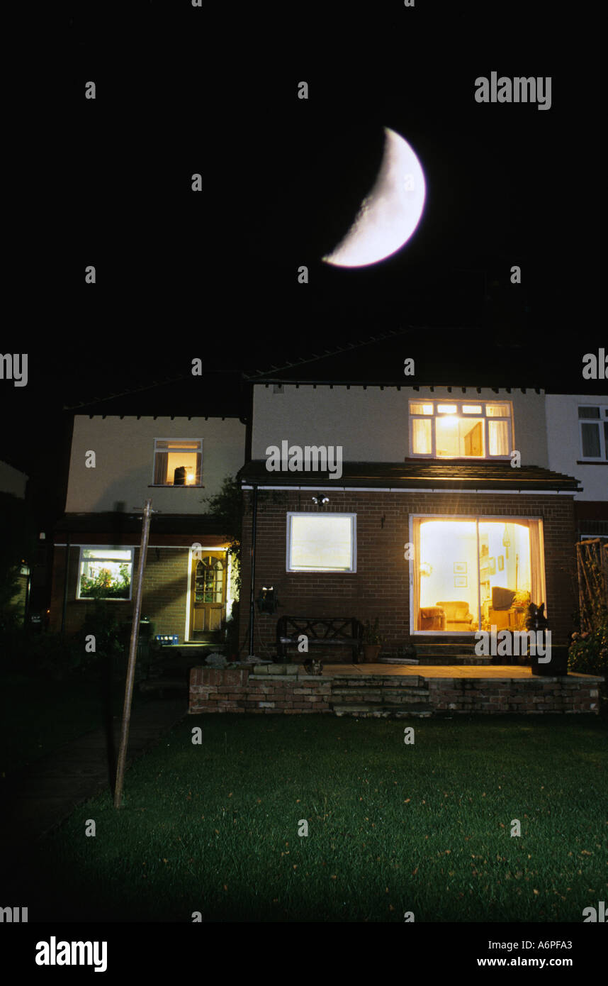 giant moon above semi detached house with lights showing at night uk ...