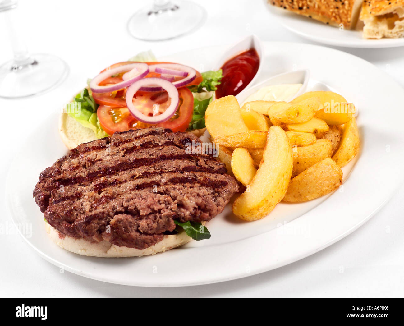 BURGER ON A BUN WITH SALAD AND POTATO WEDGES Stock Photo - Alamy
