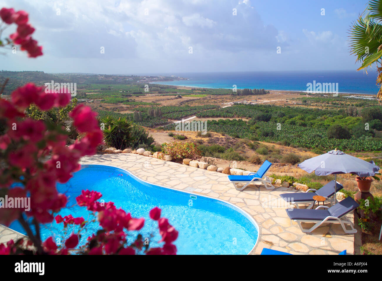 A VIEW DOWN TO A SWIMMING POOL AND OUT OVER CYPRUS LANDSCAPE WITH SEA ...