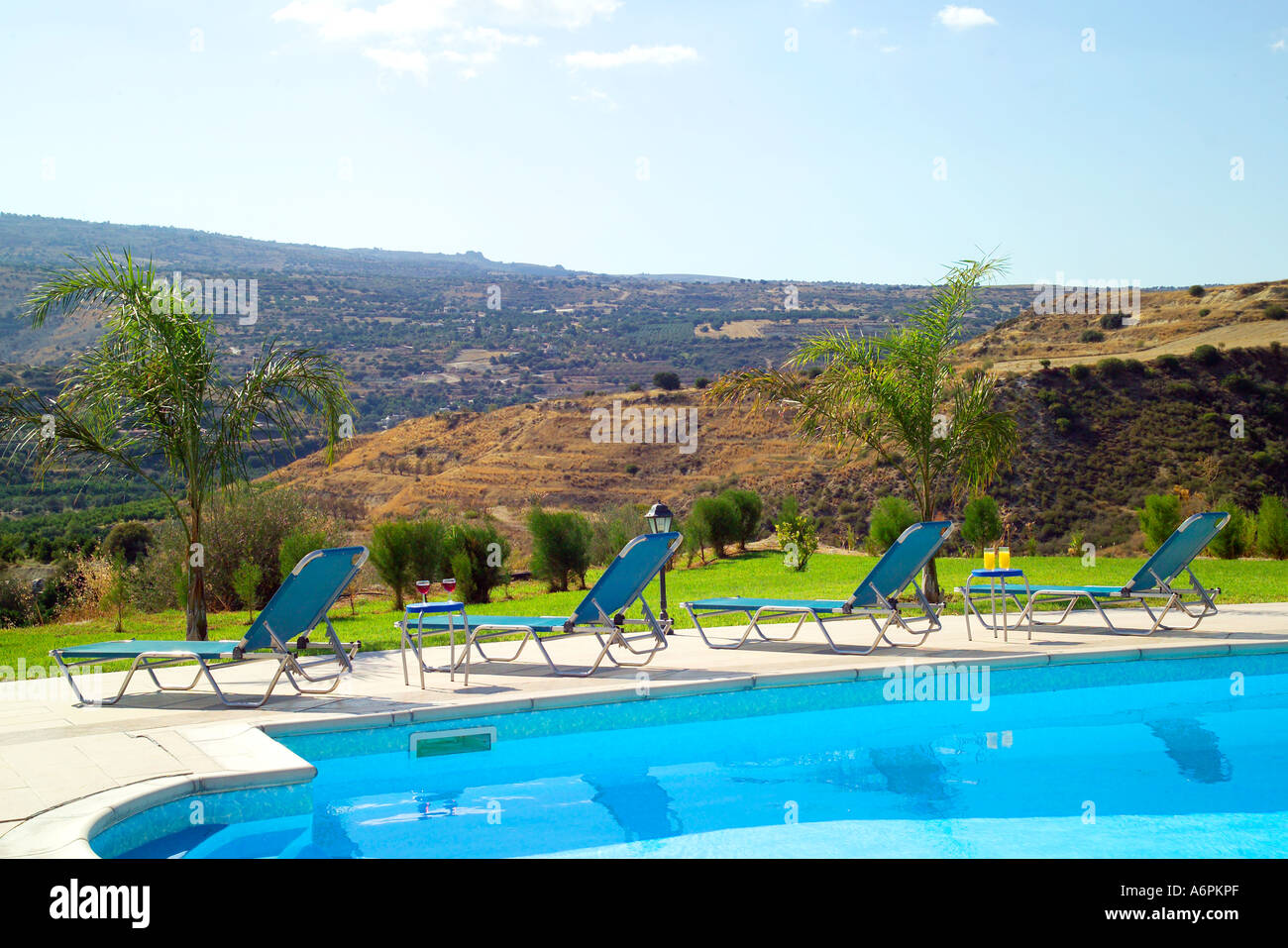 scenic view of sunbeds and swimming pool in cyprus over mountains ...