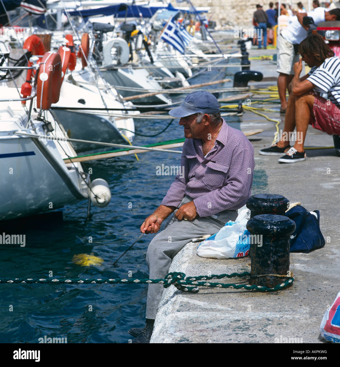 Local Man Fishing In Rhodes Harbour Rhodes Greek Islands Hellas Stock ...