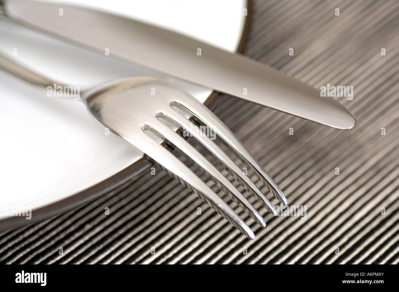 Plate with fork, knife and spoon on setting utensil Stock Photo - Alamy