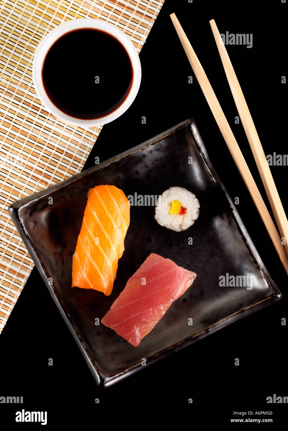 square black plate with two pieces of raw fish circle of rice wrapped ...