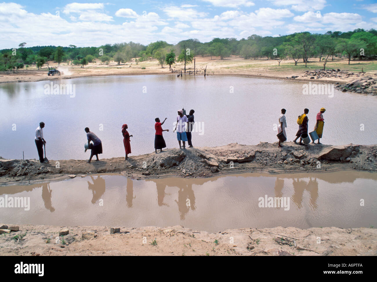 A rural community building a dam to create a reservoir in a drought ...
