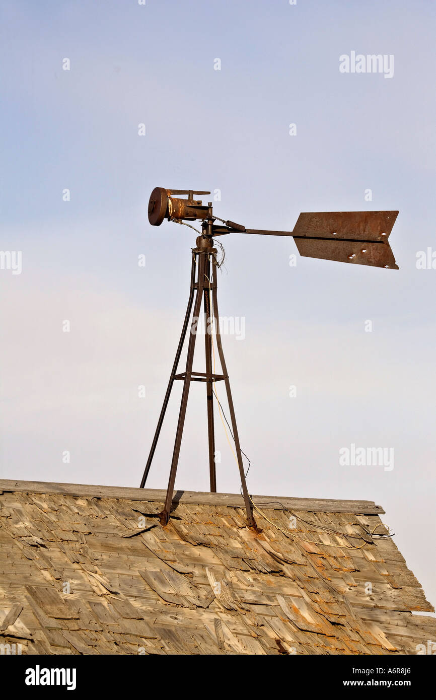 An old windmill electric generator on old farm building in scenic ...