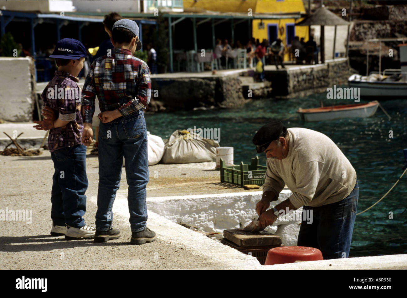 fisher man cleans fishes in a Greek island Stock Photo - Alamy